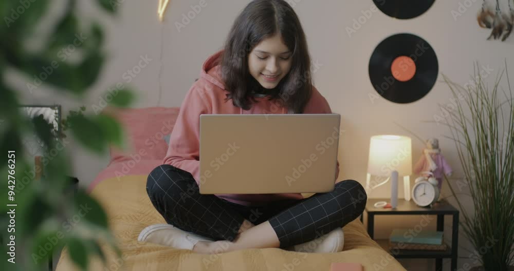 Teenage girl using laptop typing and smiling enjoying interesting ...