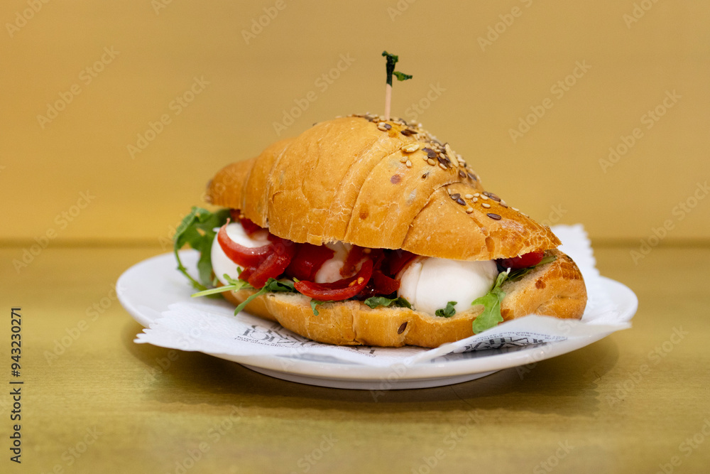 Cornetto salato ripieno di mozzarella, pomodori e rucola servito in un ...