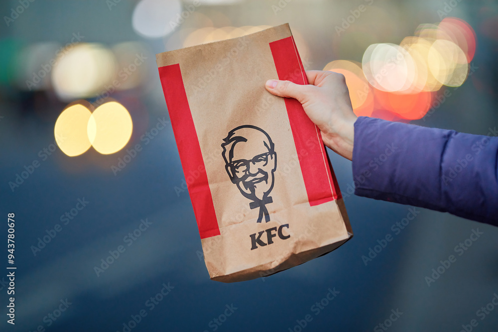 Minsk, Belarus. Mar 30, 2024. Hand holding KFC paper bag, city lights ...