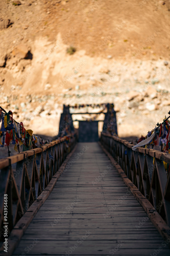 Bridge with Buddhist prayer flags on the trek path to Phuktal Gompa ...