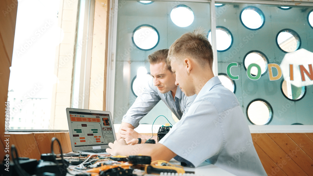 Smart student present coding program and car model to skilled teacher. Teenager using computer ...