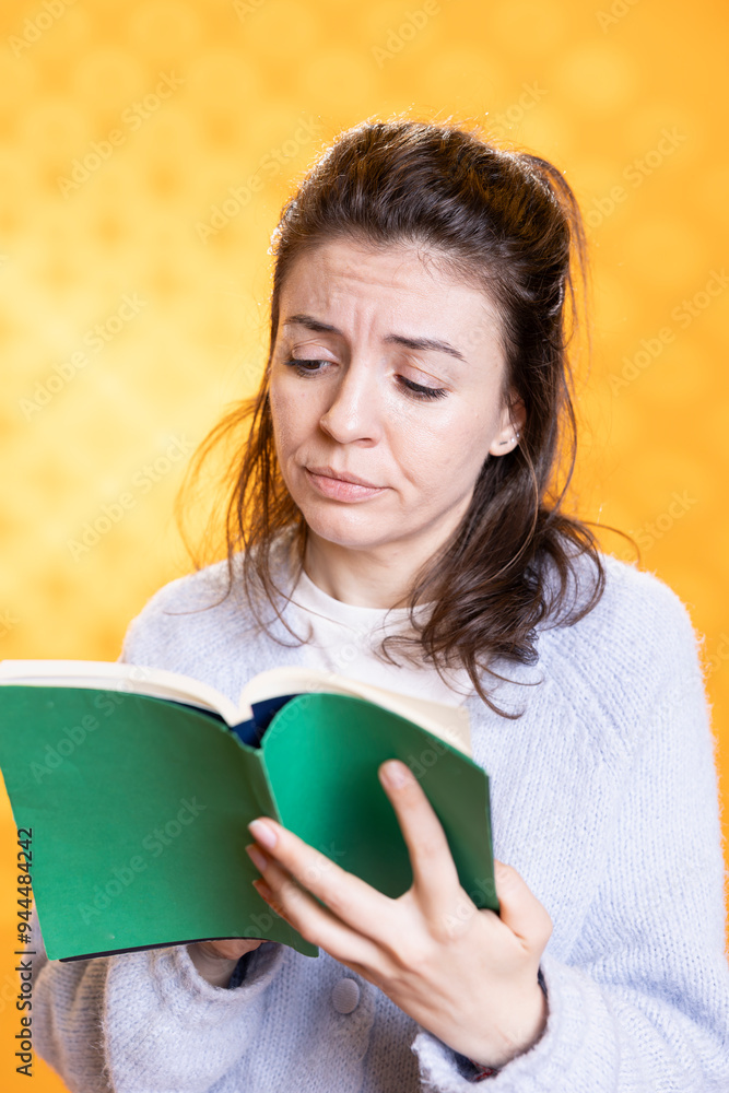 Woman frowning while gathering information for school exam in book ...