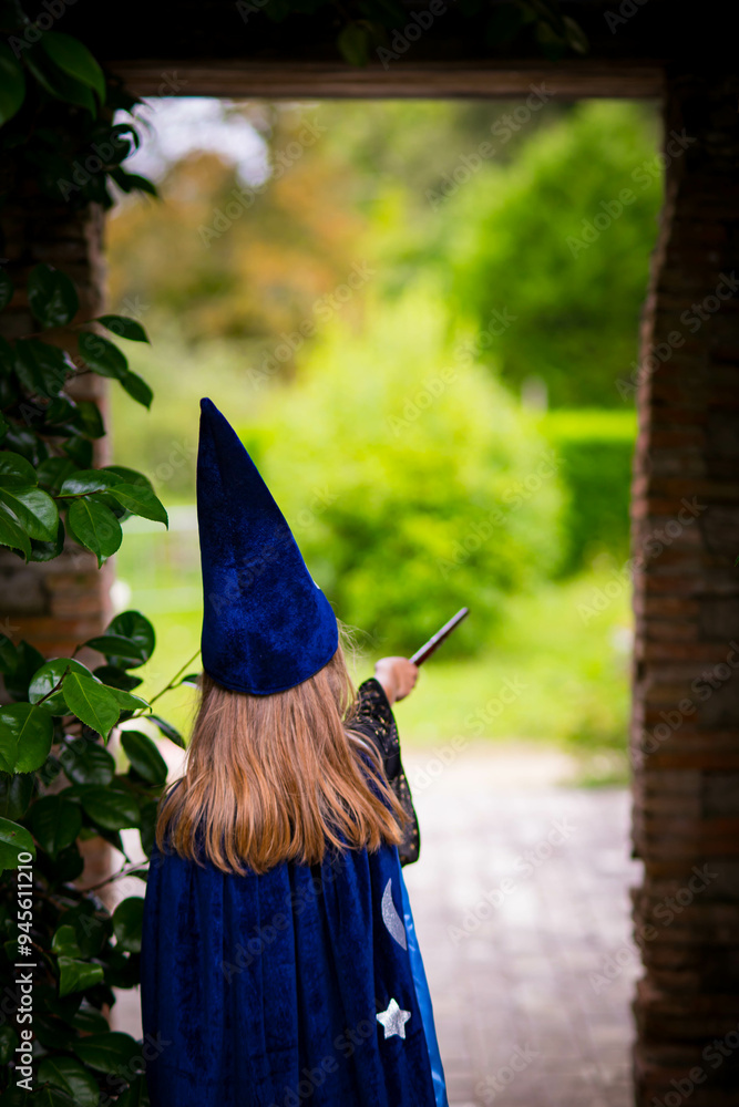 Caucasian blonde child girl in wizard blue costume with cape and hat ...