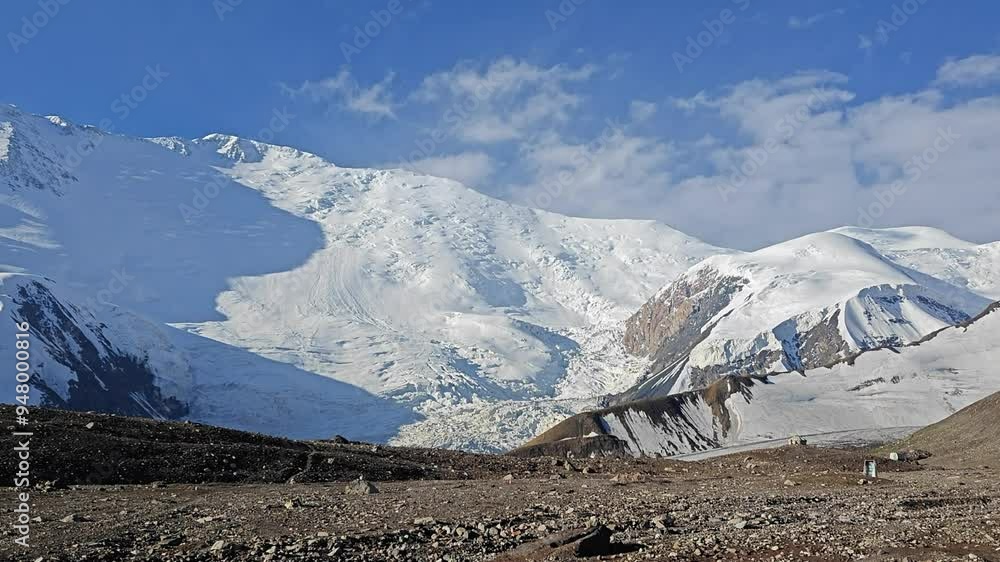A vast snow-covered mountain range under a clear blue sky, with ...