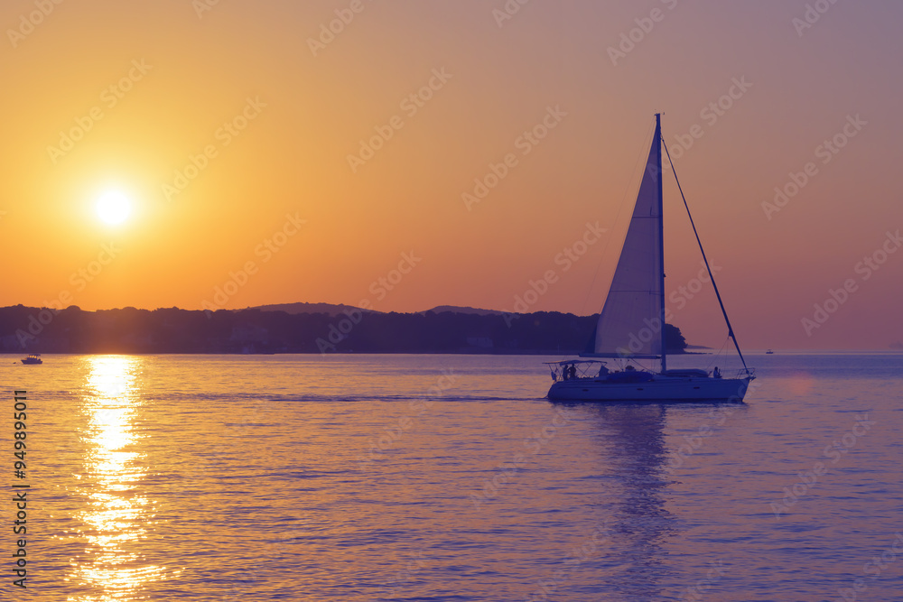 Sailboat departing at sunset. Romantic scene with a silhouetted boat ...