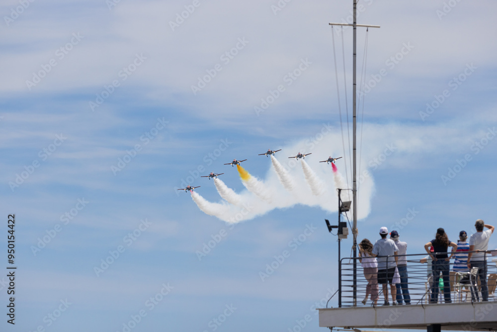 Aerial display team performs a colorful flyby near an observation deck ...