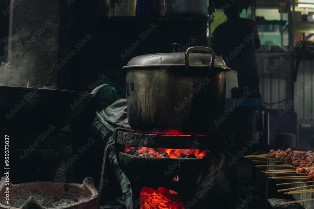 A pot of food is cooking on a stove with a lot of smoke and fire in a ...