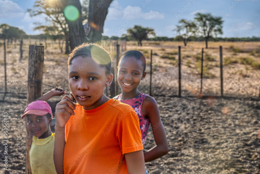 village african girls children playing in the yard in front of fence ...