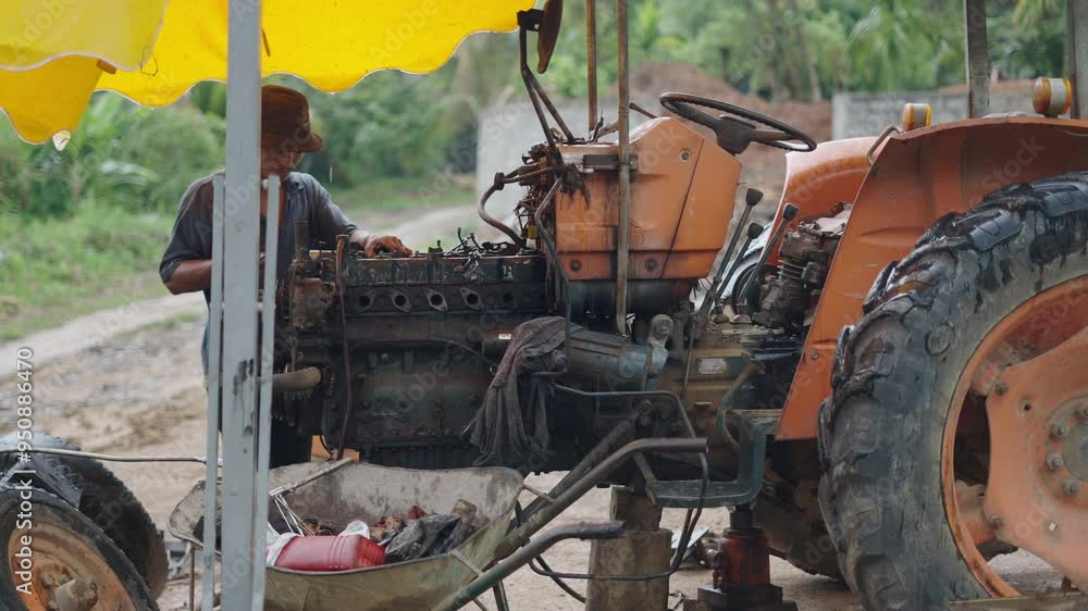 slow motion young mechanic repairing the engine of an old tractor with ...