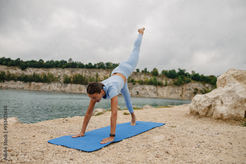 Yoga Pose by the Water Performing a Handstand while Elevating One Leg ...