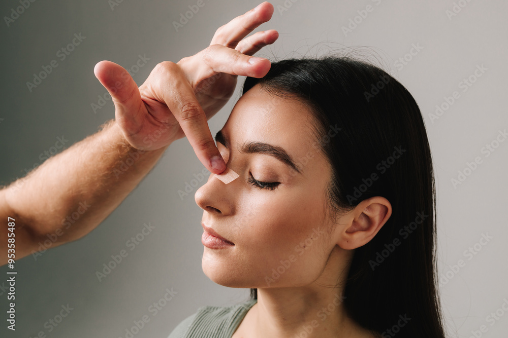 Rhinoplasty. Plastic surgeon is taping nose to patient during ...