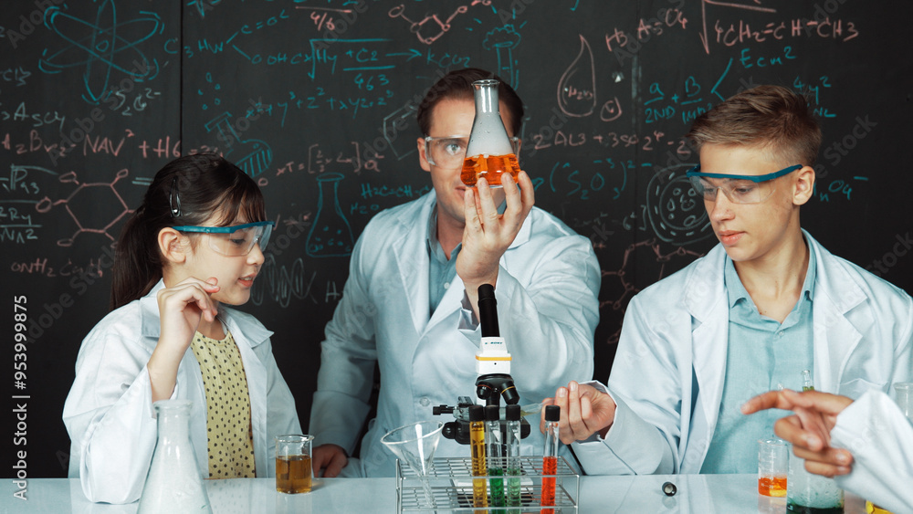 Smart teacher holding solution in beaker while student doing experiment ...