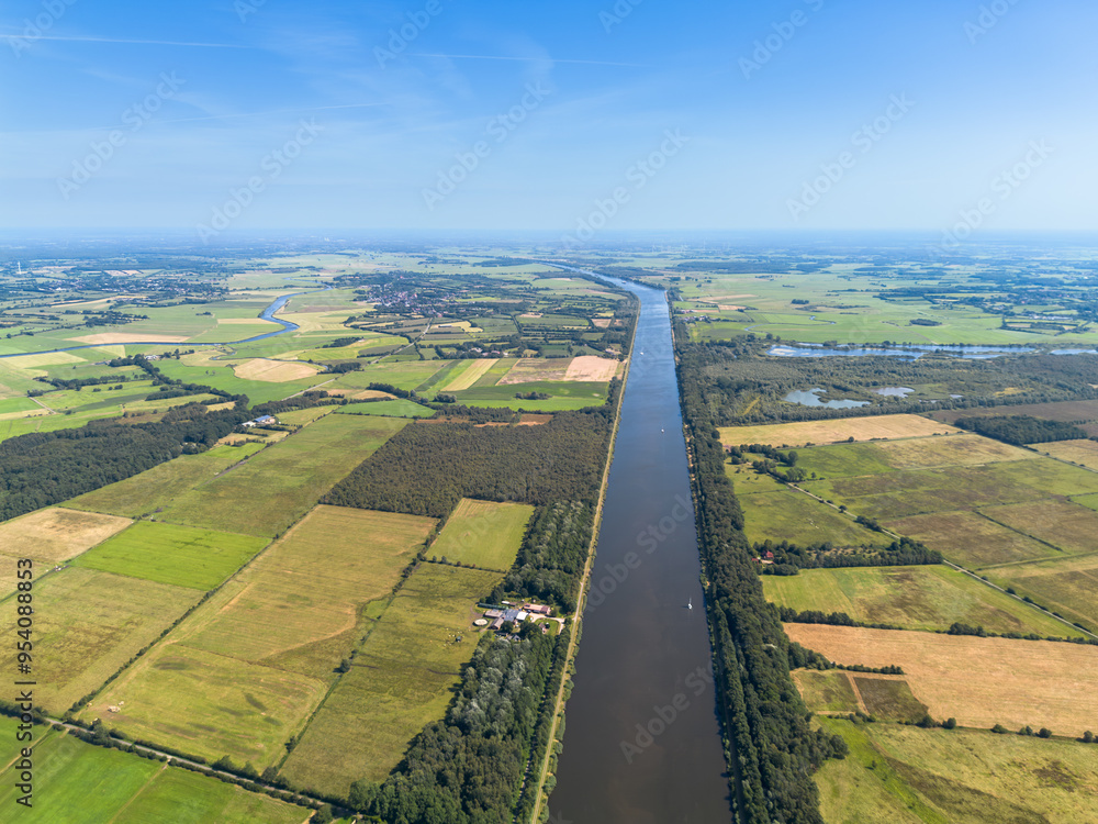 Aerial drone image of the Kiel canal, nord ostsee kanal, in Germany. Blue sky and green bank of ...