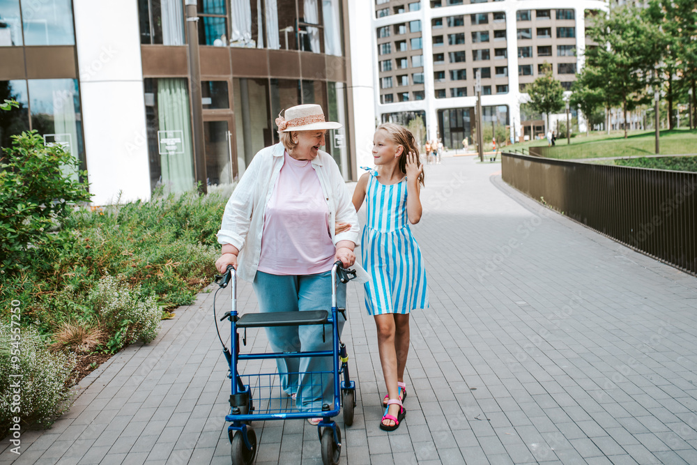 Grandma with walker and granddaugter in the city, on walk. Girl ...