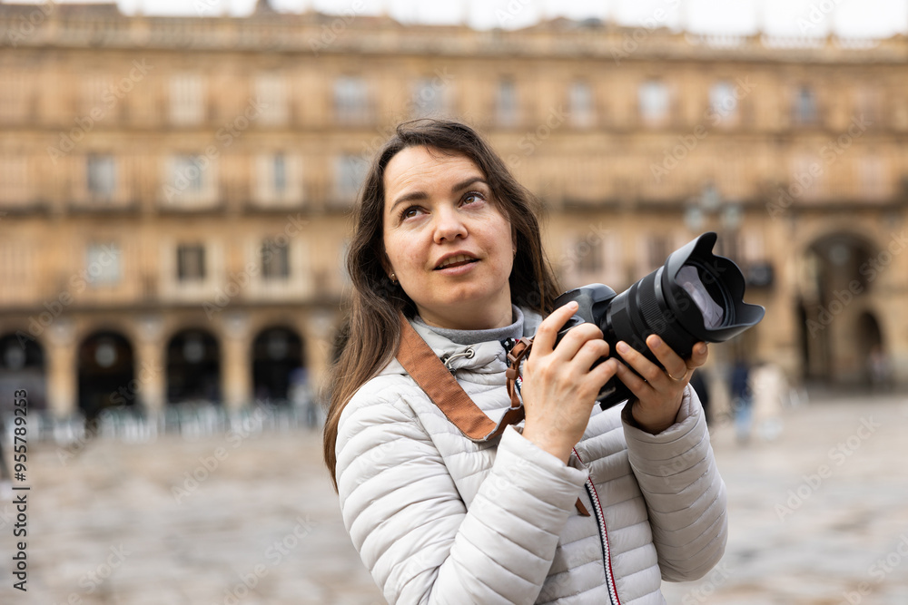 Interested woman photographer walking with camera on Plaza Mayor of ...