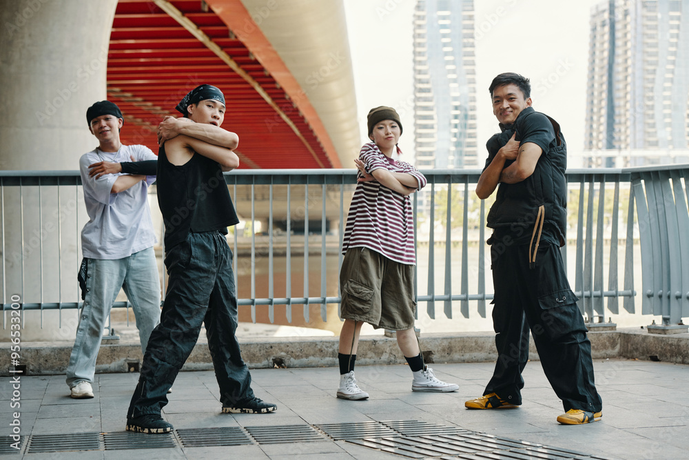 Group of friends standing together underneath urban bridge with city ...