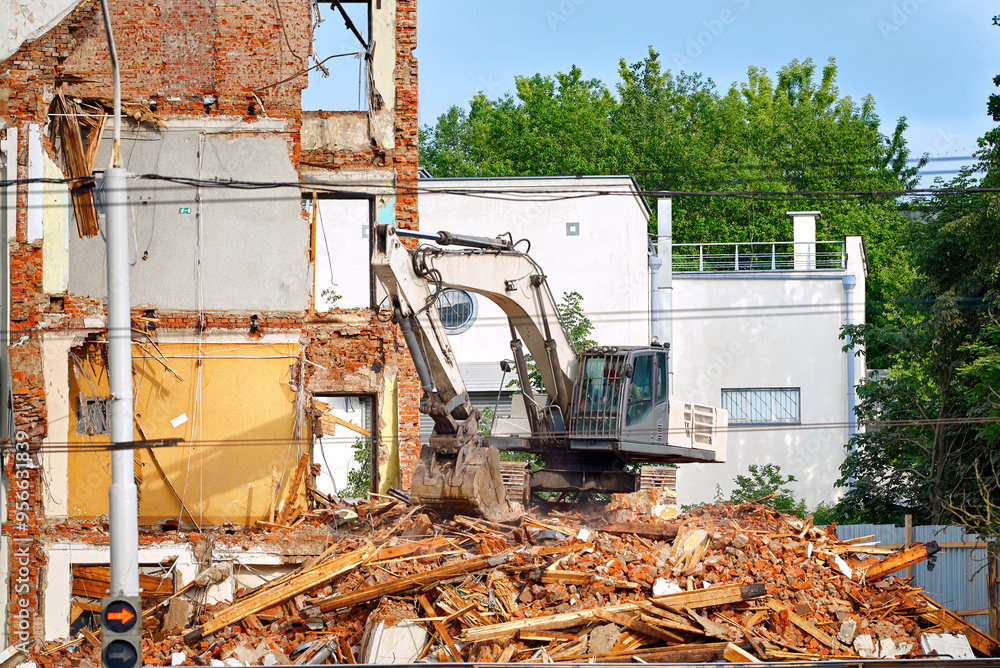 Powerful excavator at work, demolishing building and creating scene of ...