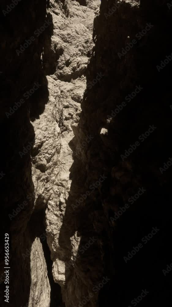 A narrow passage between two towering rocks in a natural cave formation ...
