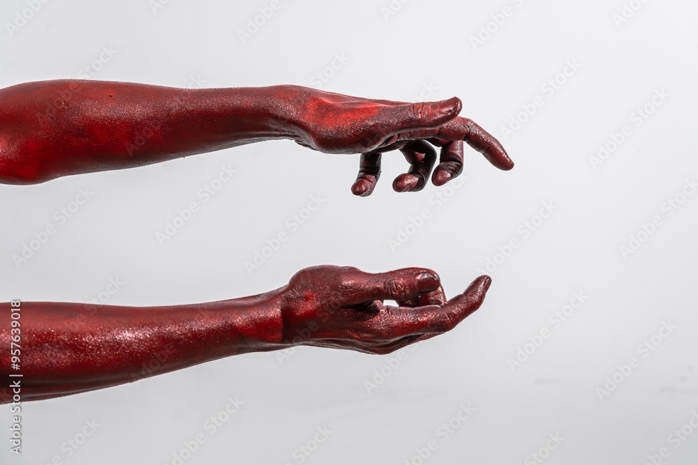 A terrifying red demon hand, reaching out menacingly on white studio ...