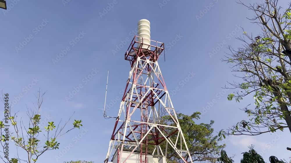 A tall tsunami warning siren tower stands prominent against a bright ...