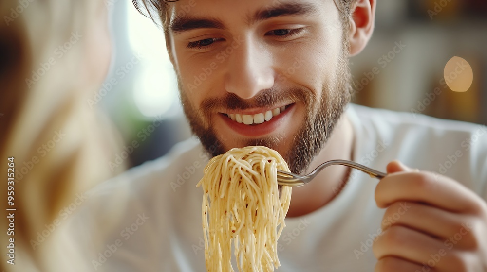 Man tasting spaghetti pasta while smiling woman look at him Closeup ...