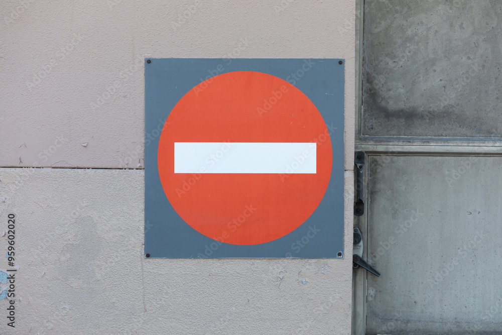 Do not enter exit only warning sing on a wall near metallic garage ...