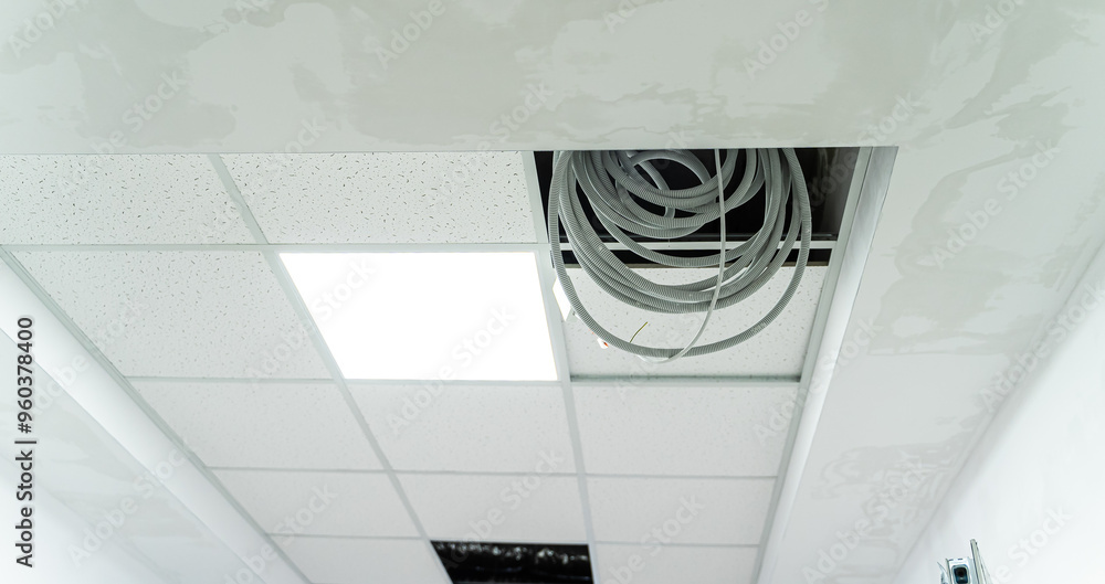 Ceiling repair process showing exposed wiring in a commercial building ...
