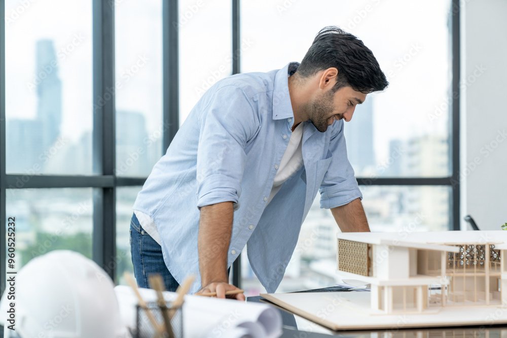 Professional architect engineer inspecting house model while designing ...