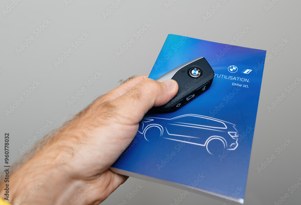 Munich, Germany - Sep 2, 2024: A male hand holds the sleek new BMW key ...