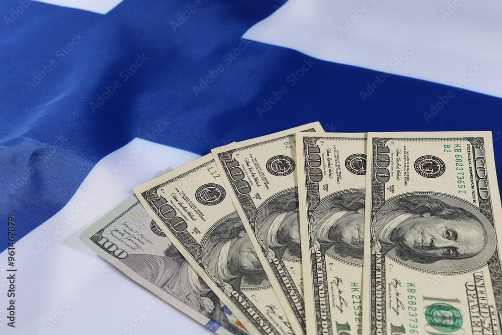 Finland flag and US dollar bills on display in a creative arrangement ...