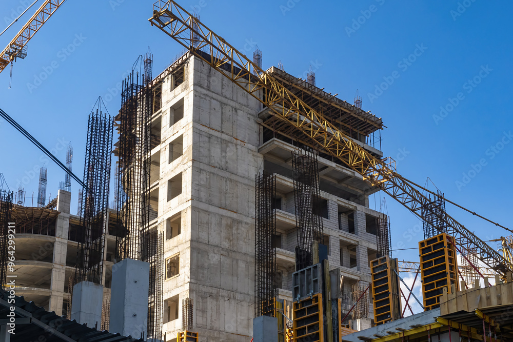 Scenery with buildings under construction. Crane boom over construction ...
