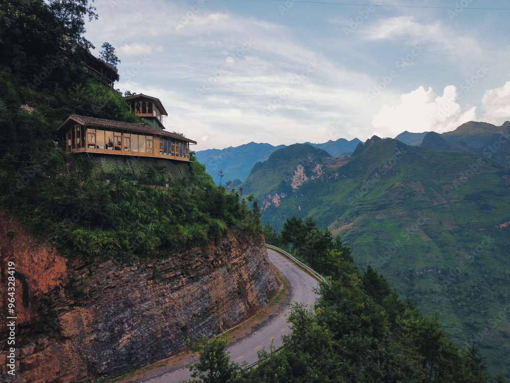 Hanging houses on the Ha Giang Loop with a road passing below them. The gorge marks the frontier ...