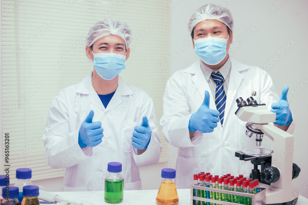 Two male researchers are conducting chemical research in a science lab ...