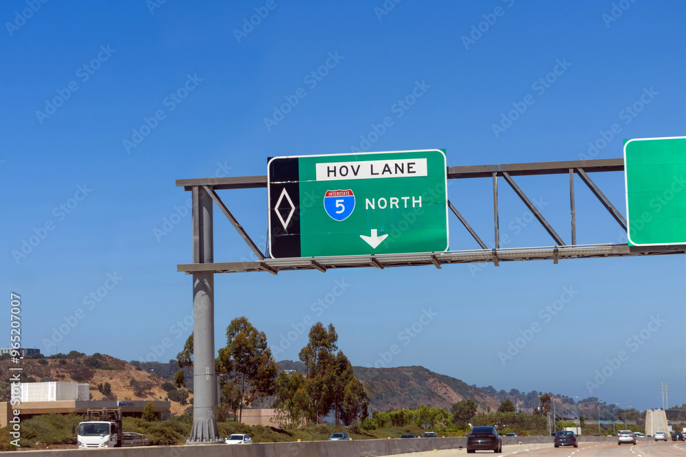 A highway overhead sign directing vehicles to the HOV lane on ...