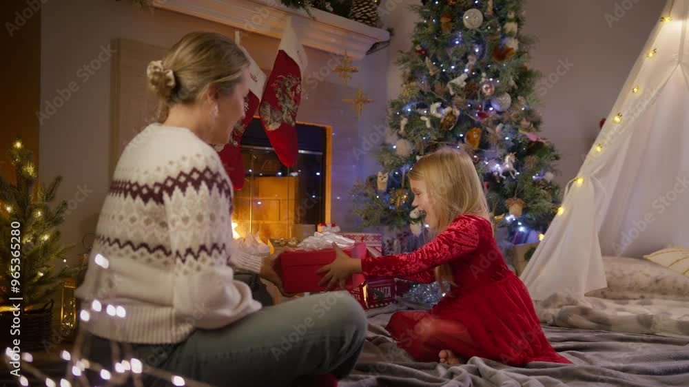 Captured in a warm, festive setting, a mother surprises her delighted ...