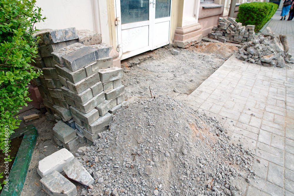 Building entrance repair with disassembled paving slabs and porch ...