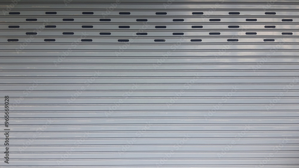 Rolling door. Steel shutter door of warehouse. The shutters are gray ...