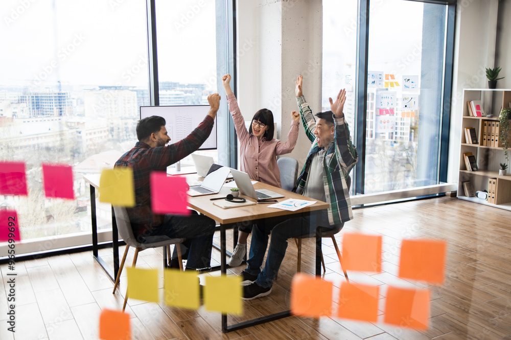 Group of young professionals celebrating success in modern office. High ...