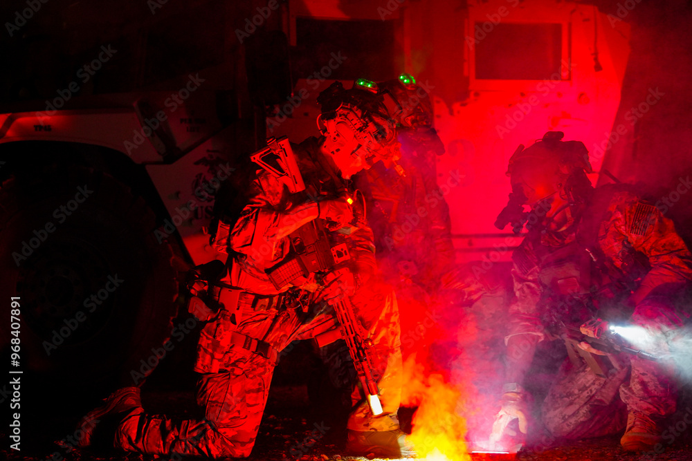 soldiers wearing combat gear gather around a flare during military ...