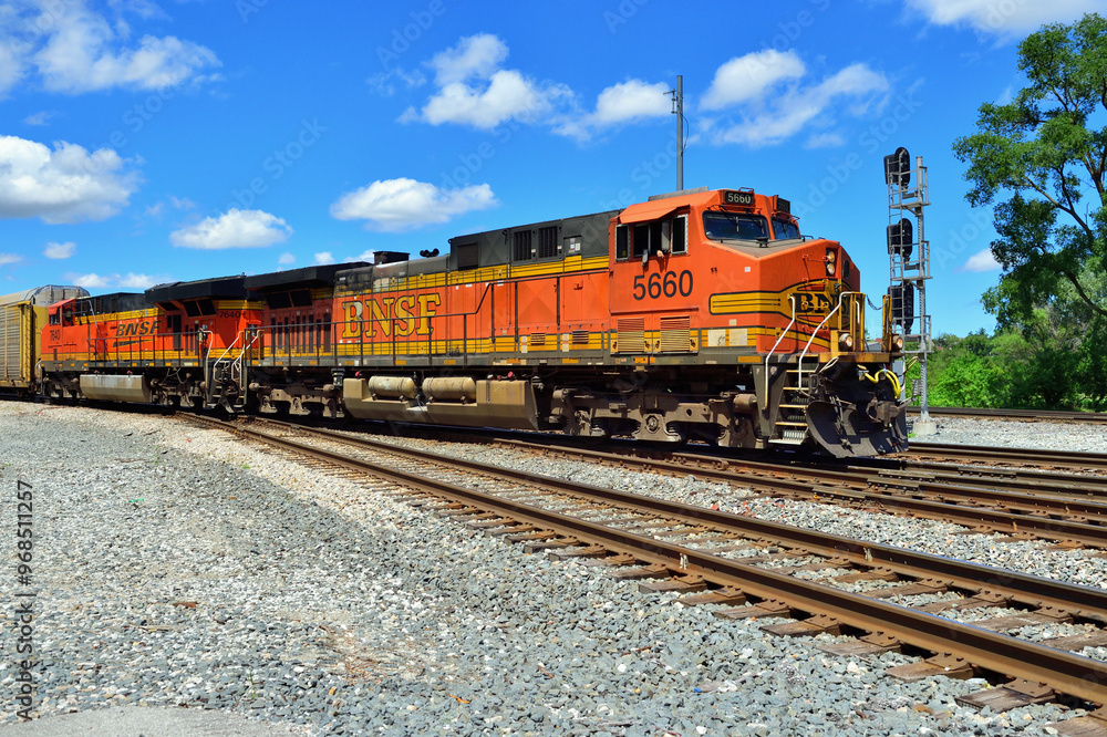 Burlington Northern Santa Fe locomotives lead an auto rack freight train through one of the ...