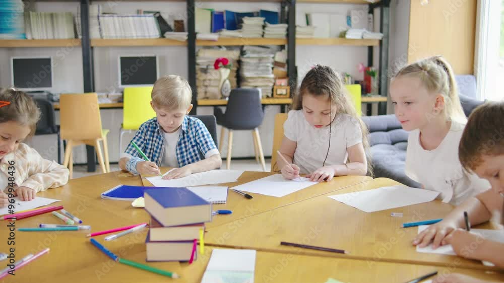 Elementary school children are fully engaged in an art class, drawing ...