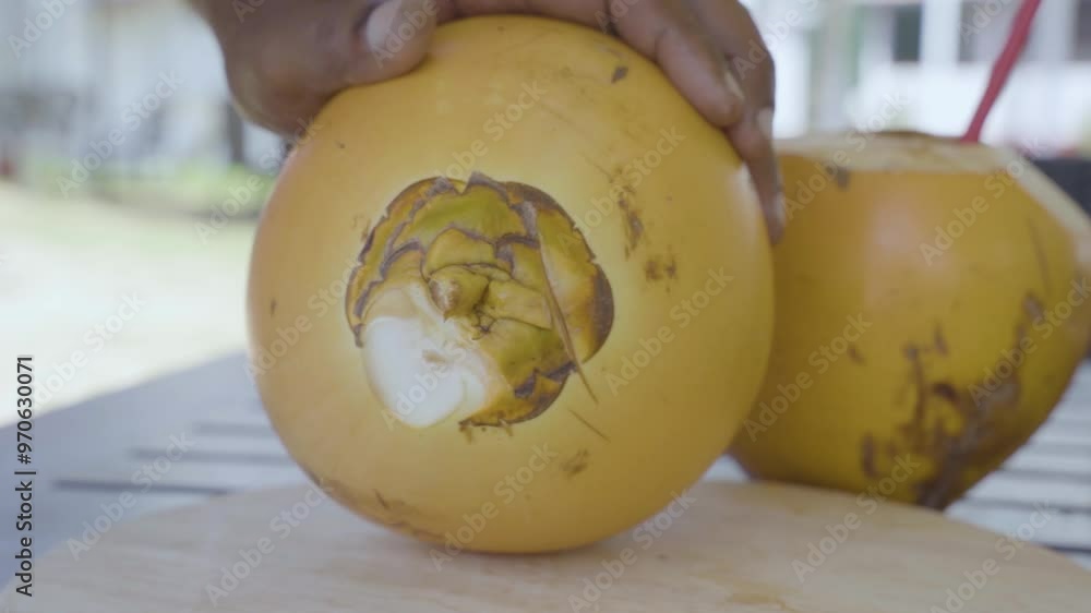 A king coconut being rotated and expertly cut, revealing its refreshing ...
