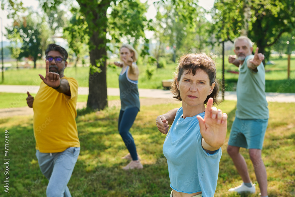 Elderly brunette woman in blue t-shirt looking at camera while ...