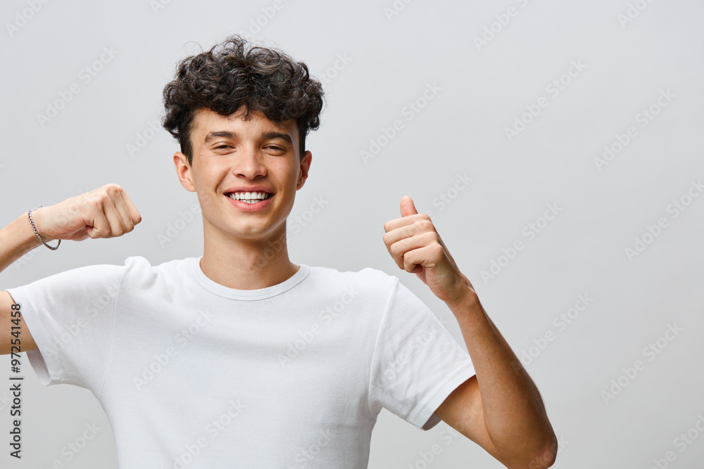Smiling young man showing excitement with thumbs up gesture in a ...