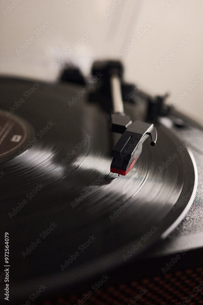 Turntable headshell and tonearm playing music from a vinyl record with ...
