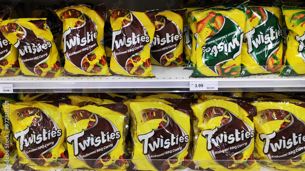 Assortment flavoured of a TWISTIES corn snack on a supermarket shelf ...