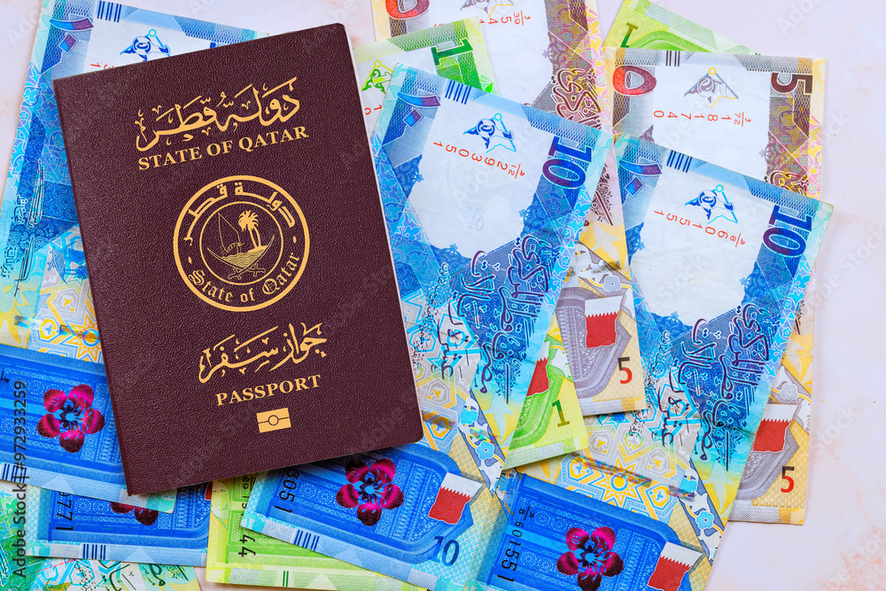 Passport issued by State of Qatar with Qatari banknotes in currency ...