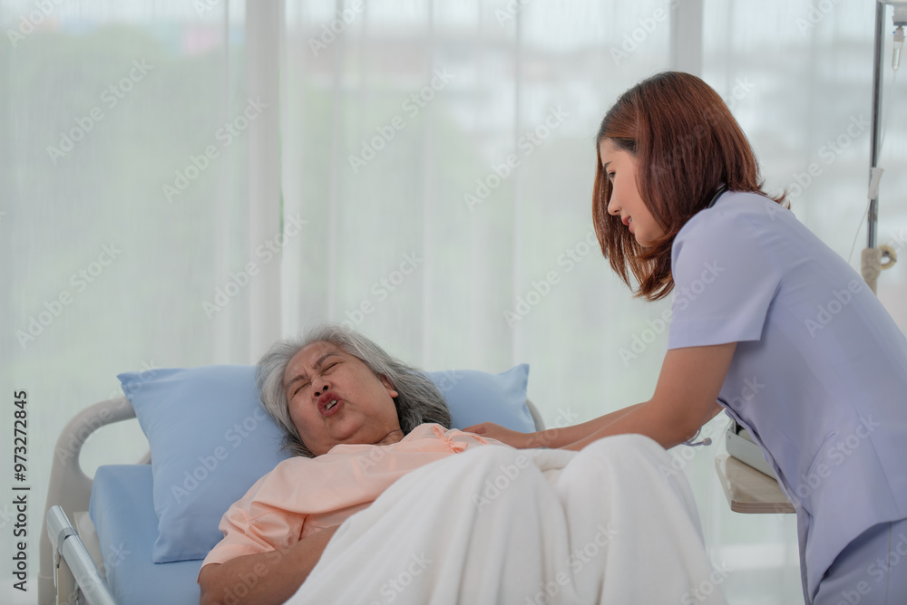 Asian nurse helping a senior Asian female patient with stomach ache on ...