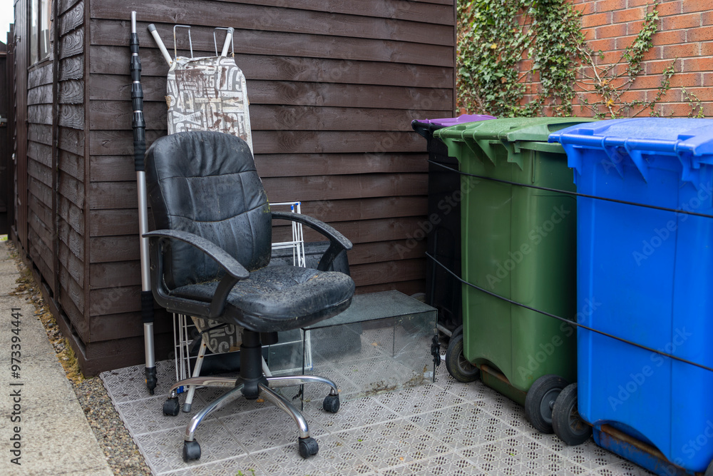 Domestic waste office chair ironing board and pole beside row of ...