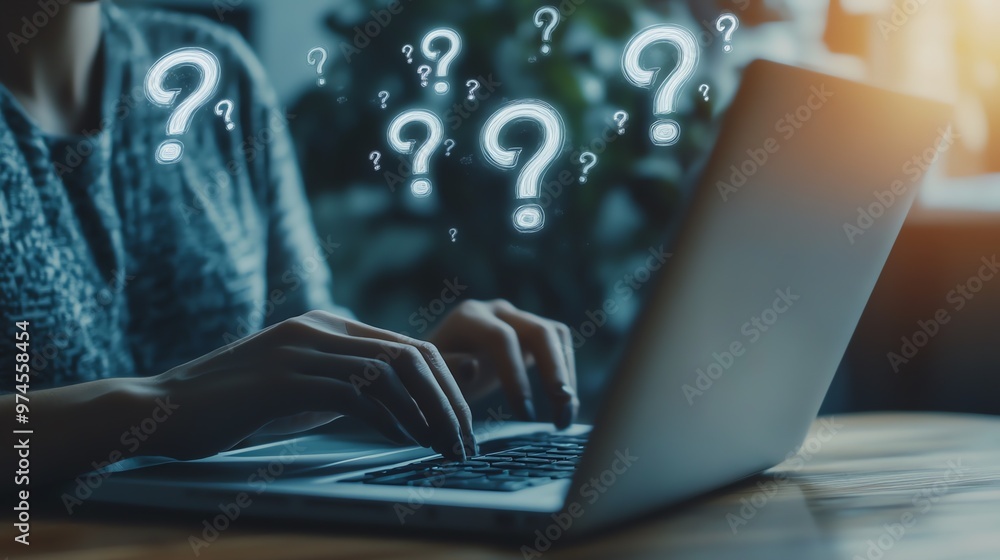 A person typing on a laptop with question marks floating above the ...